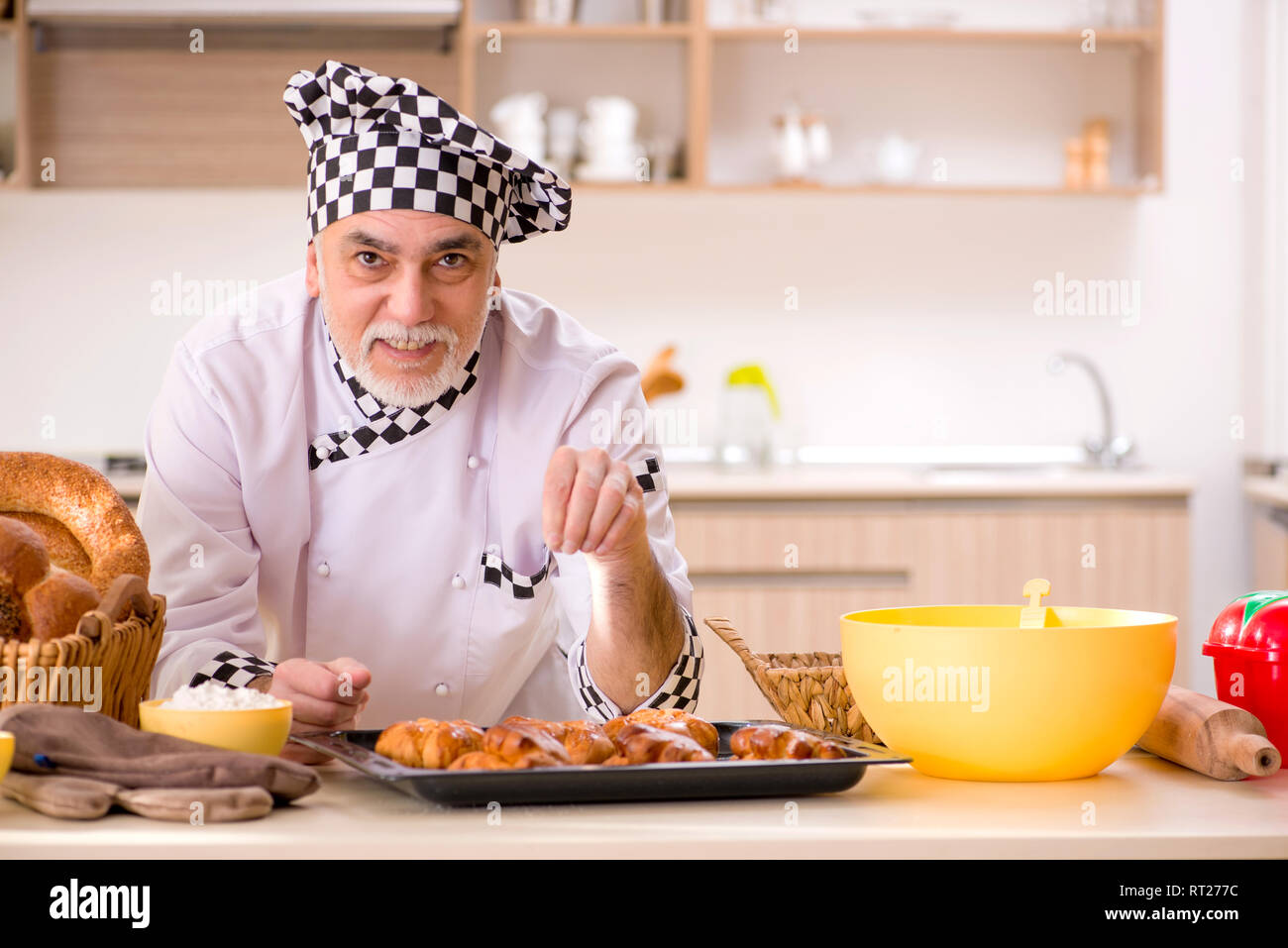 Old male baker working in the kitchen Stock Photo - Alamy