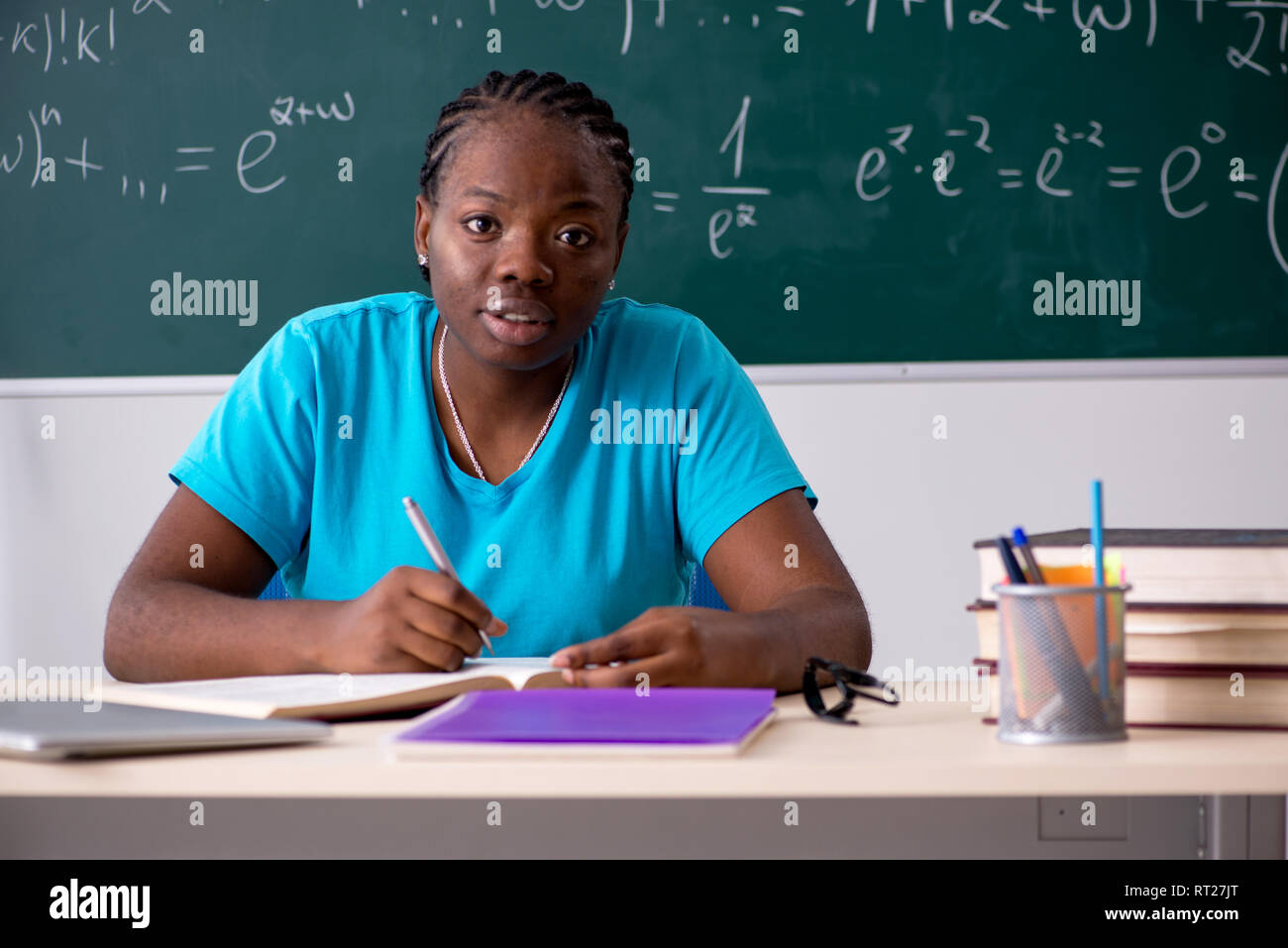 Black female student in front of chalkboard Stock Photo - Alamy