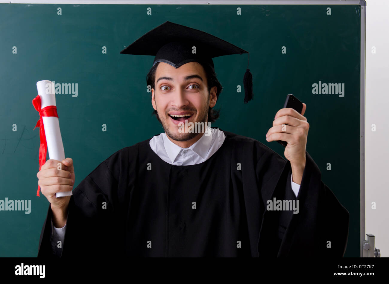 Graduate student in front of green board Stock Photo - Alamy