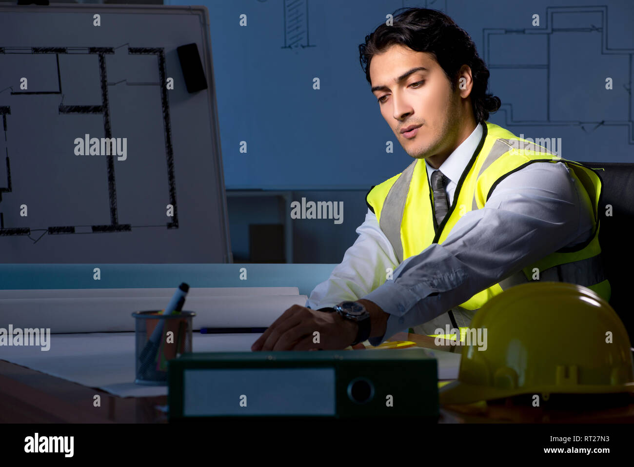 Young construction architect working on project at night Stock Photo ...