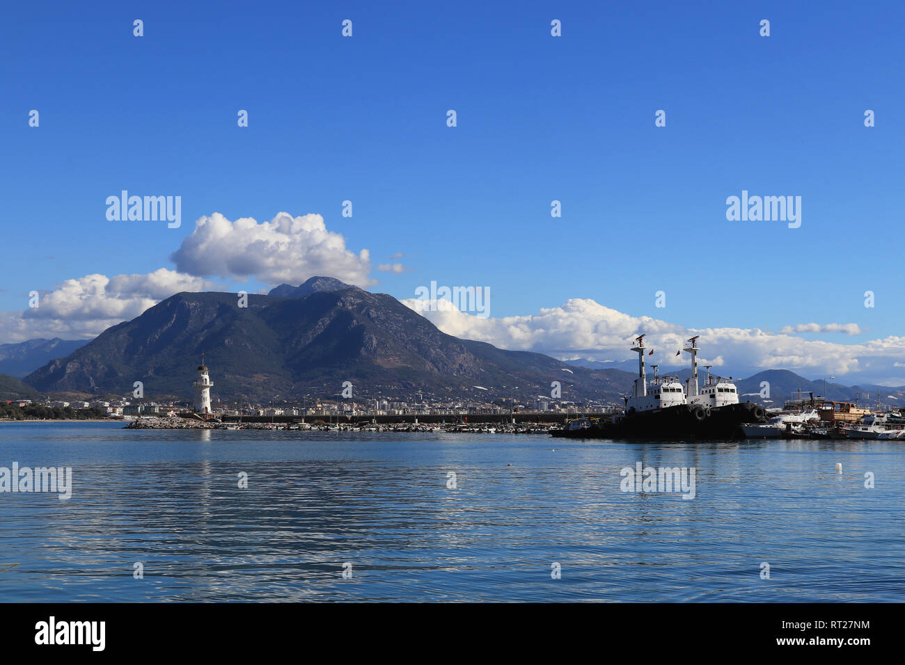 Marina bay landscape with two tows and lighthouse on breakwater pier ...