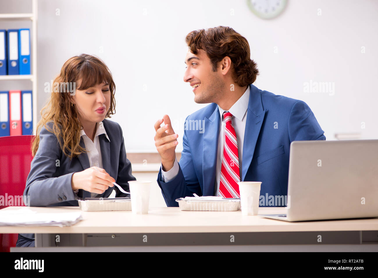 Two colleagues having lunch break at workplace Stock Photo - Alamy