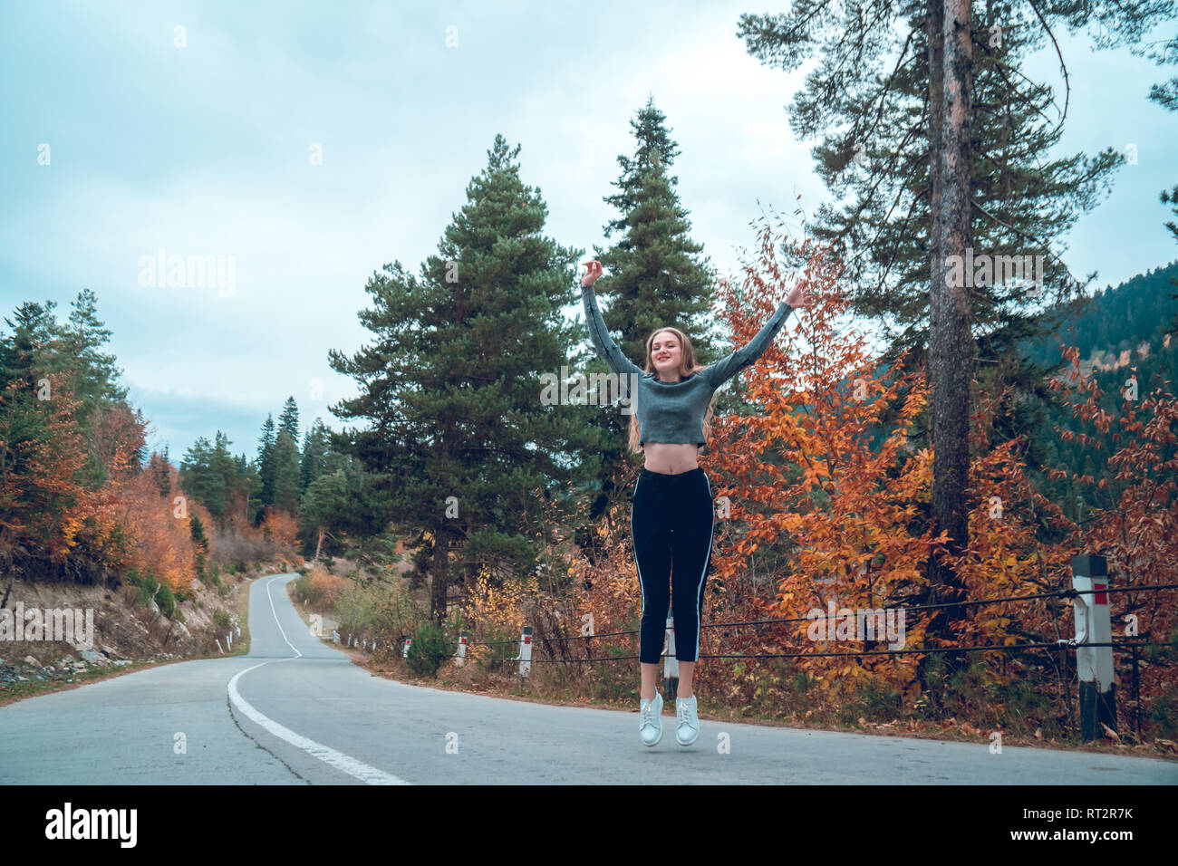 beautiful young girl jumping for joy on the road in Svaneti, Georgia Stock Photo - Alamy