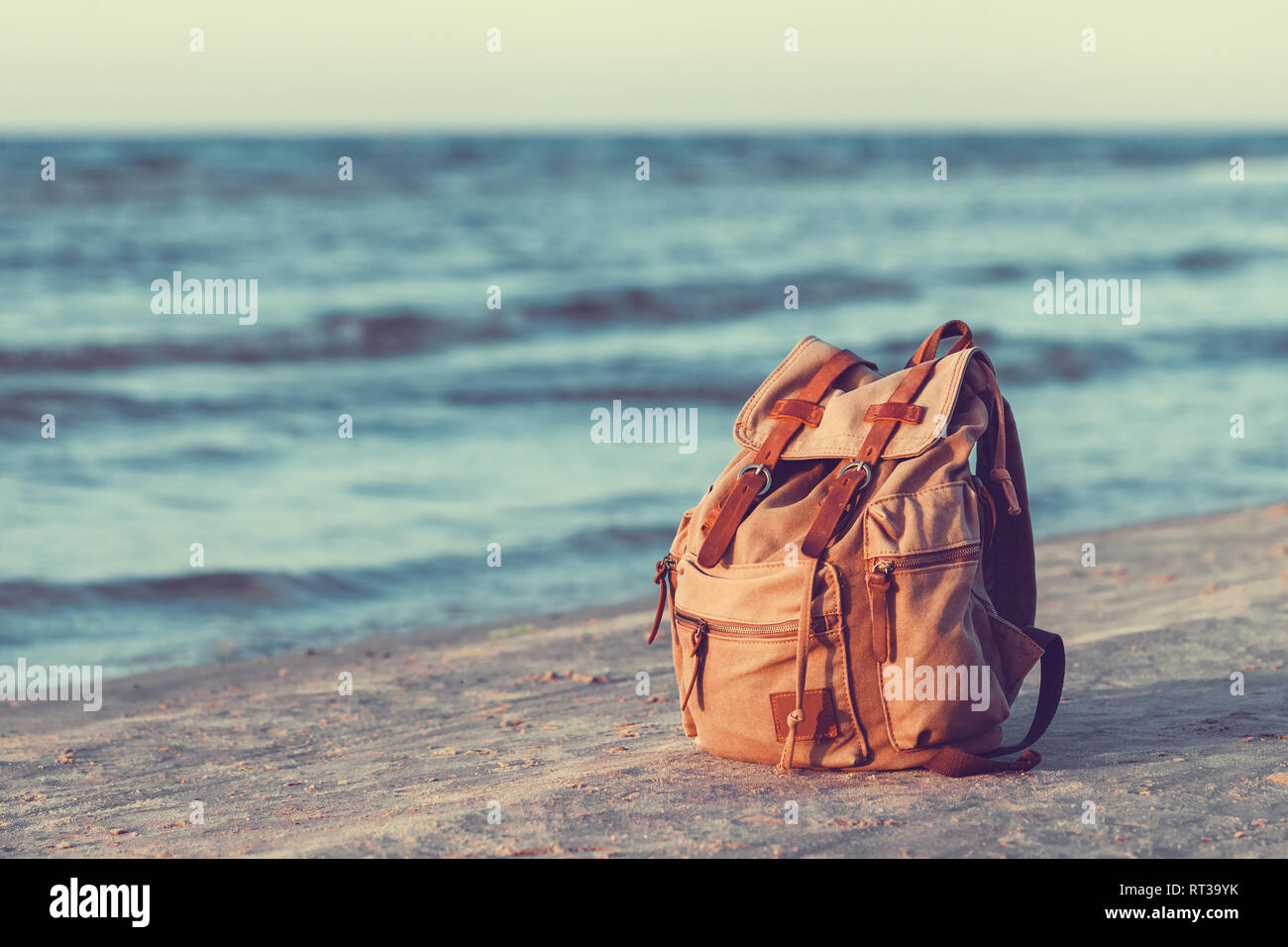 Travel Canvas Backpack on Sea Beach. Retro styled Stock Photo - Alamy