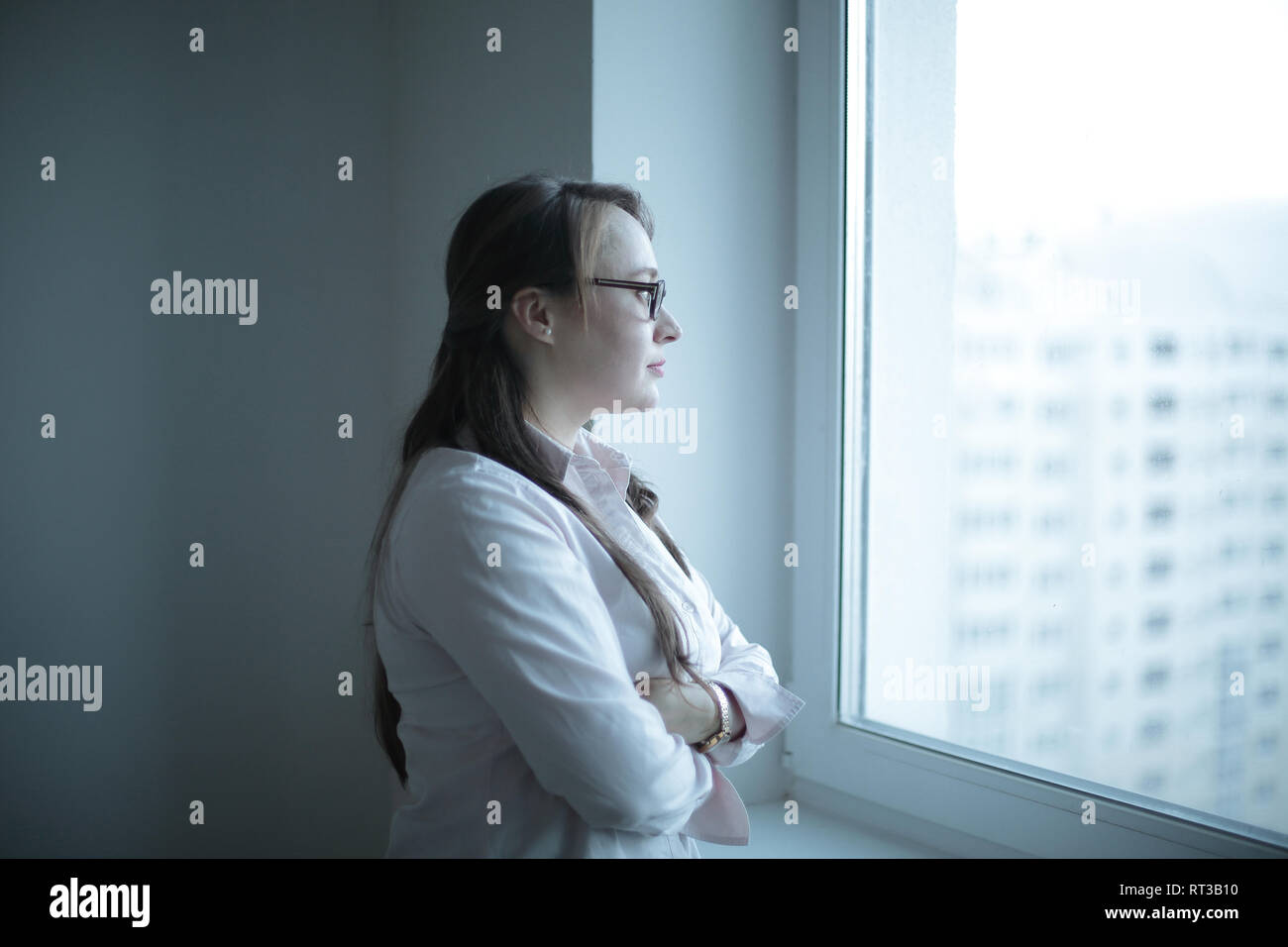 Executive business woman looking out the office window Stock Photo - Alamy
