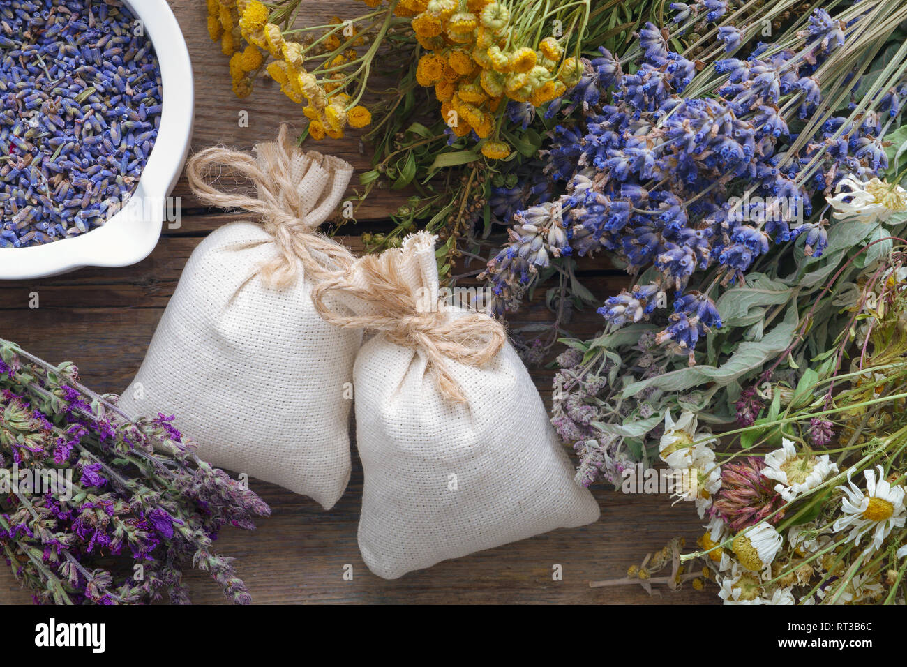 Bunch of healing herbs, mortar and sachet on wooden table. Herbal ...