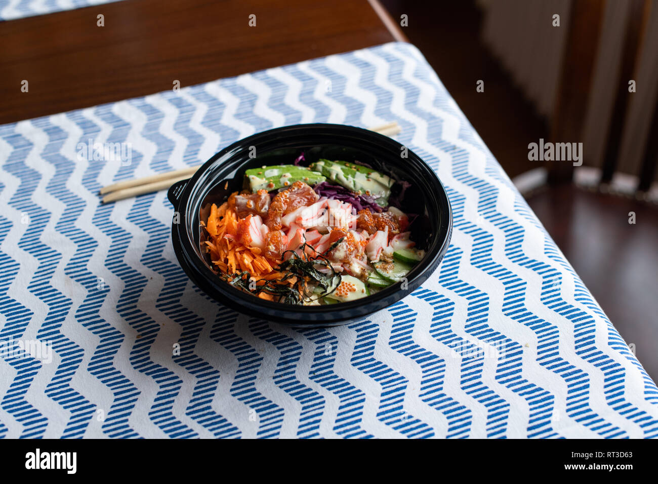 hawaii poke bowl with salmon, rice, surimi, avocado, tobiko, carrot and ...