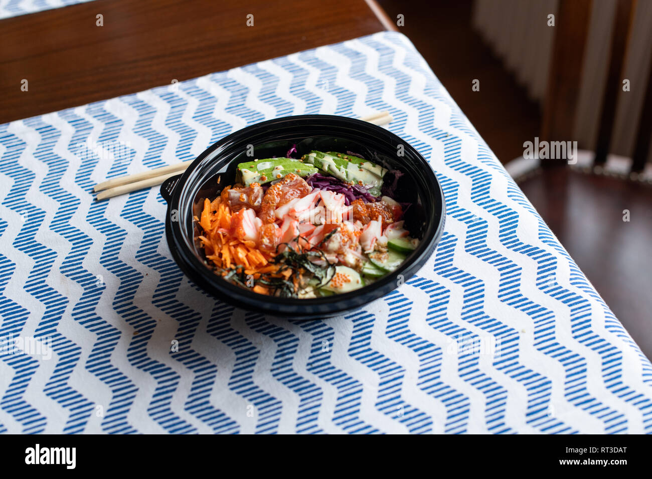 hawaii poke bowl with salmon, rice, surimi, avocado, tobiko, carrot and ...