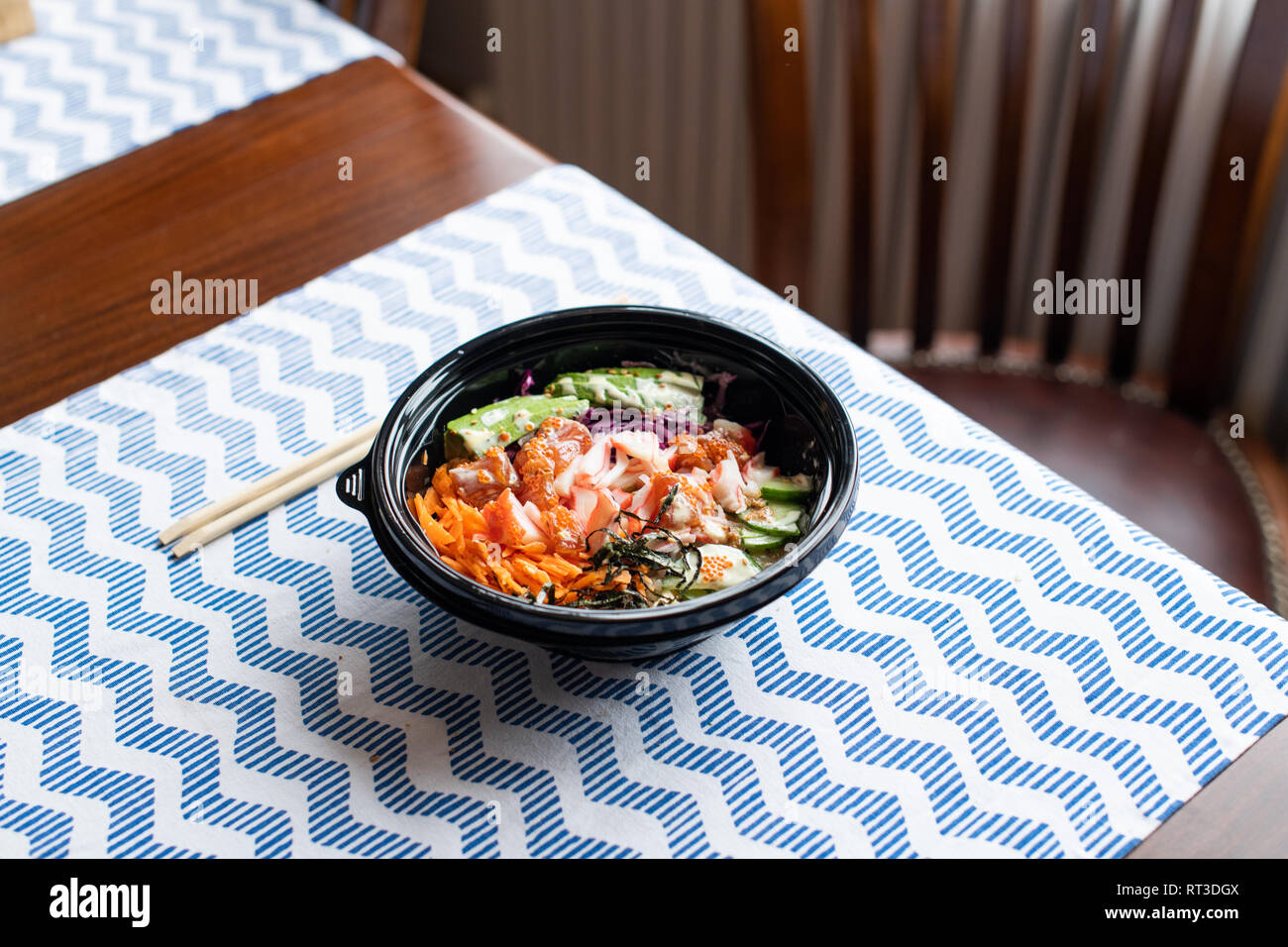 hawaii poke bowl with salmon, rice, surimi, avocado, tobiko, carrot and ...