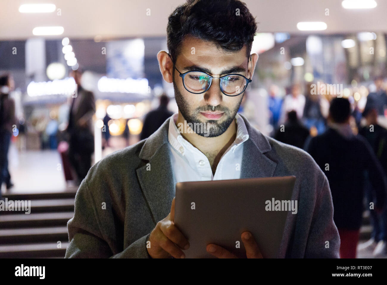 Germany, Munich, portrait of young businessman using digital tablet at ...