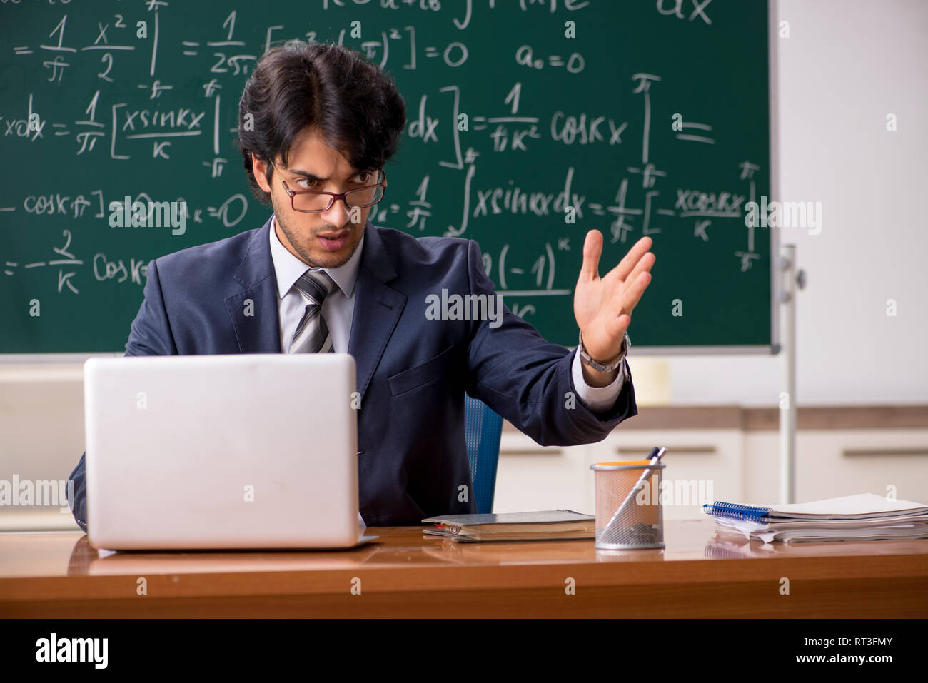 Young male math teacher in classroom Stock Photo - Alamy