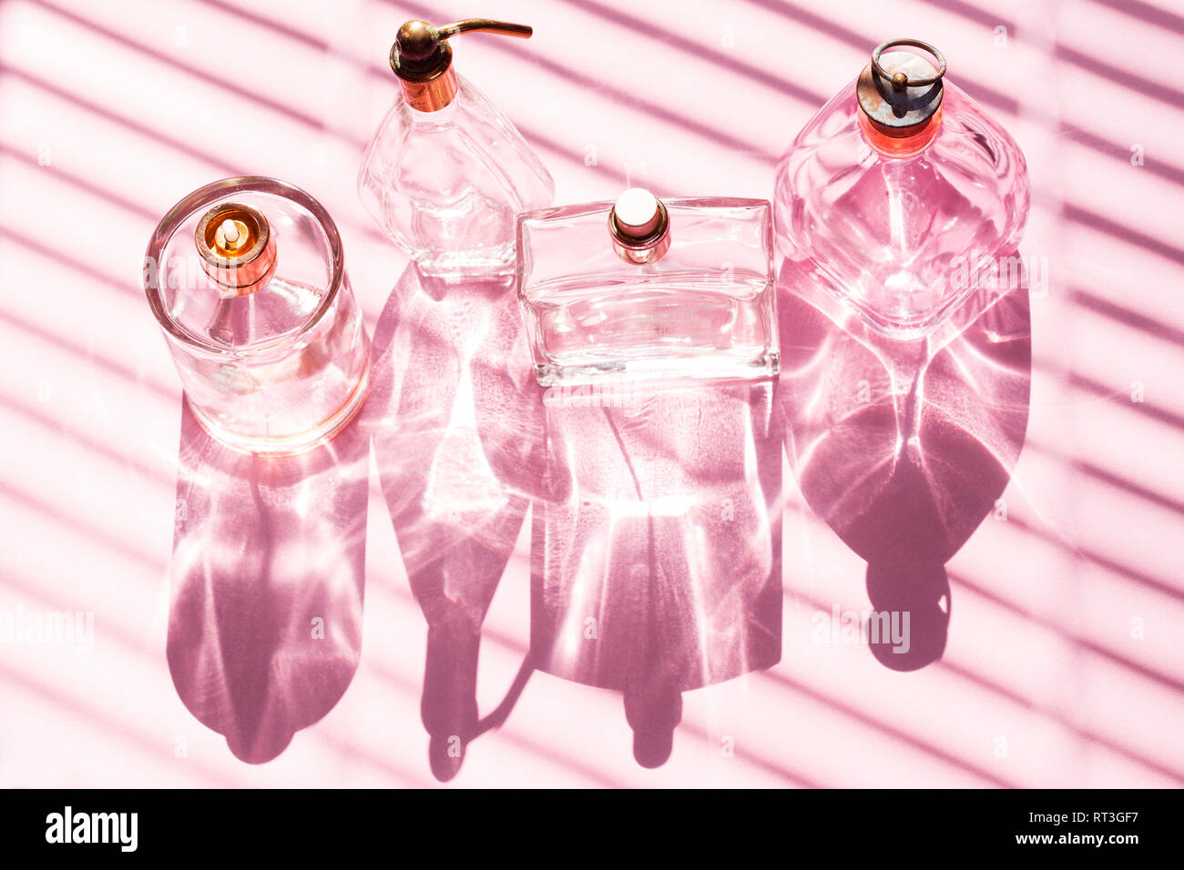 Perfume bottles on bright light with the shadows Stock Photo - Alamy
