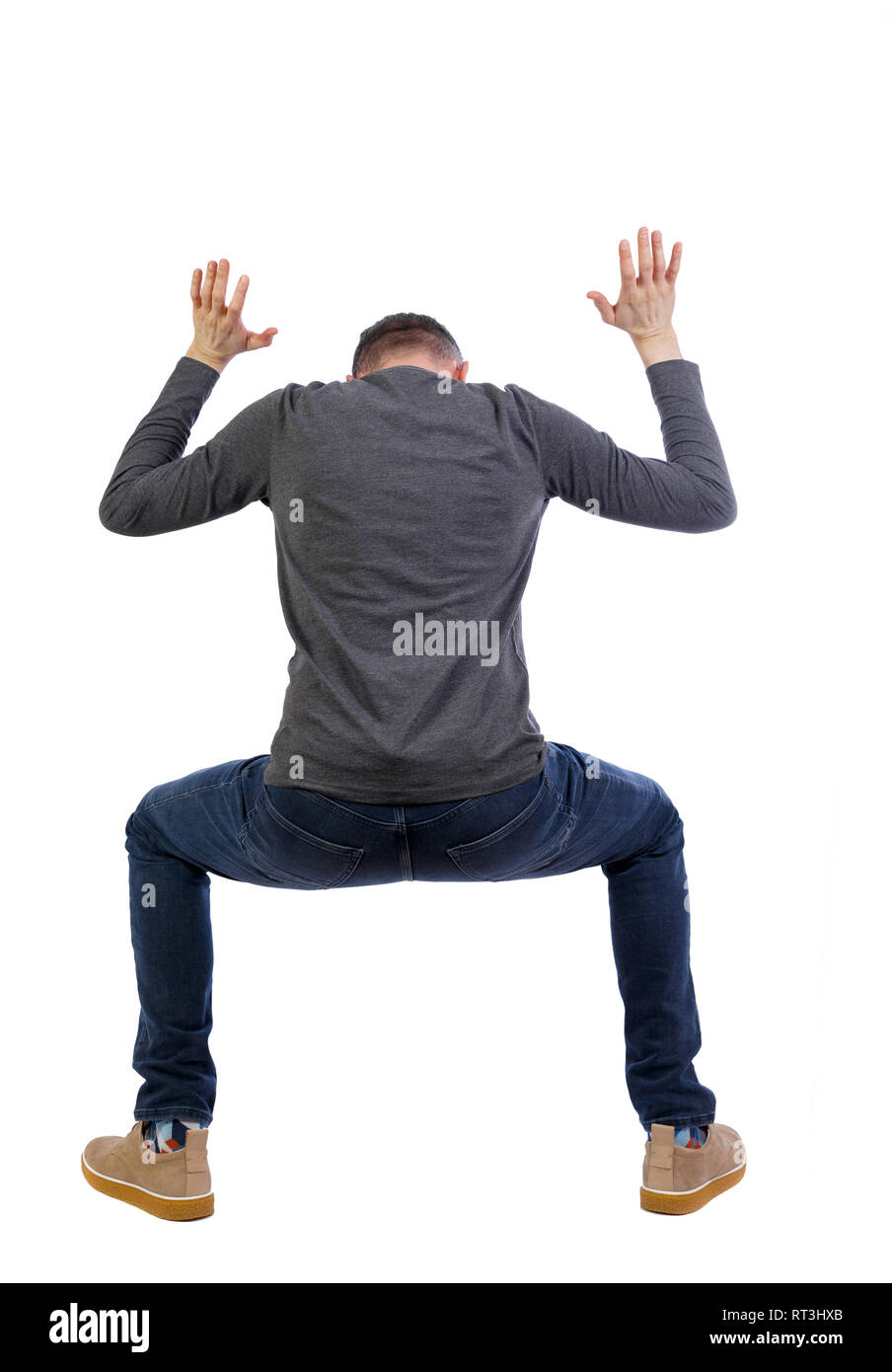 back view. man protects hands from what is falling from above. Man ...