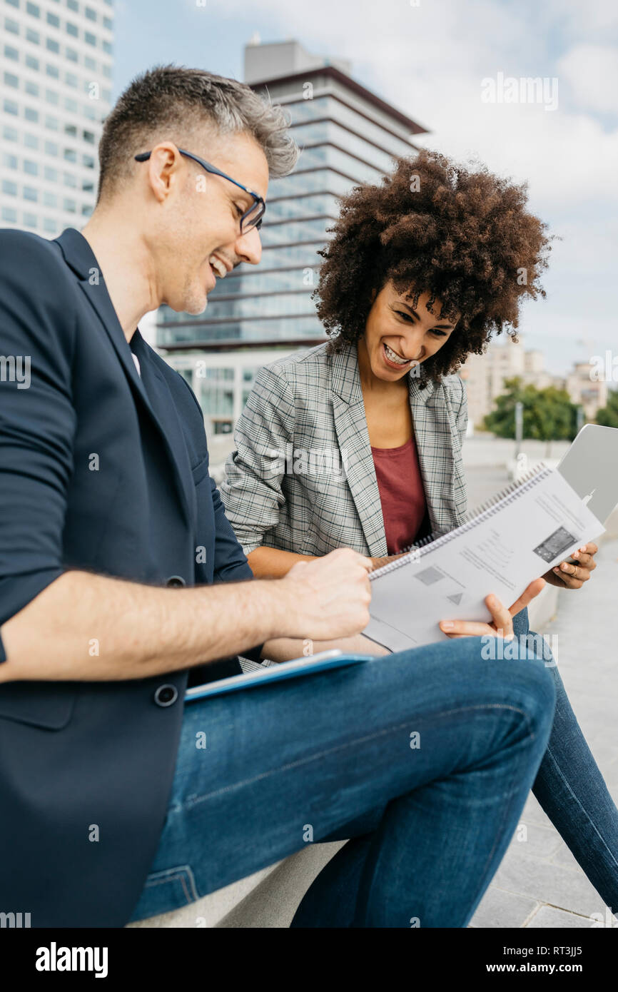 Two happy colleagues working together outside office building Stock ...