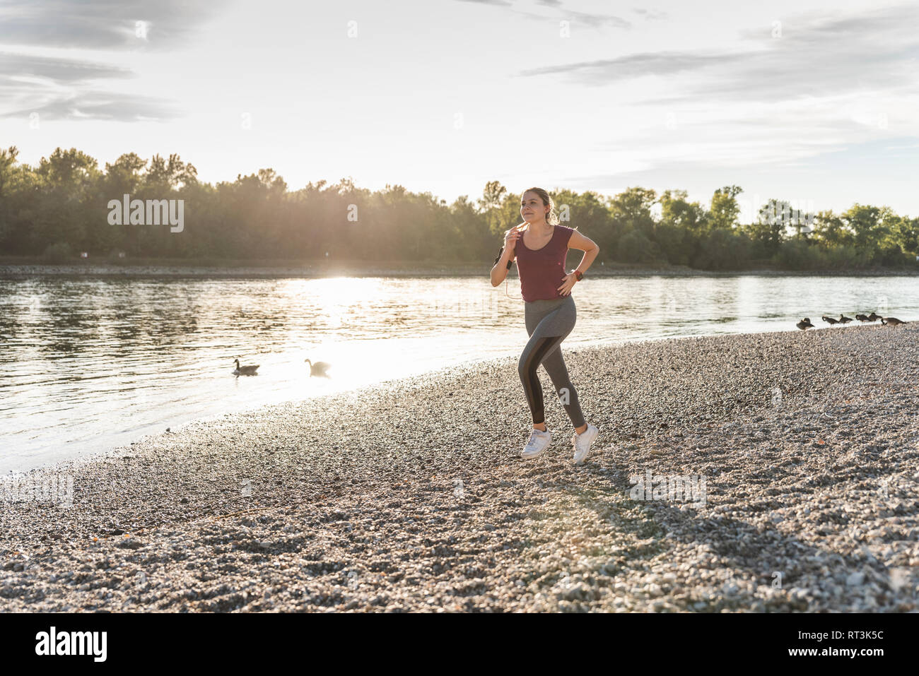 Young woman jogging at he river Stock Photo - Alamy