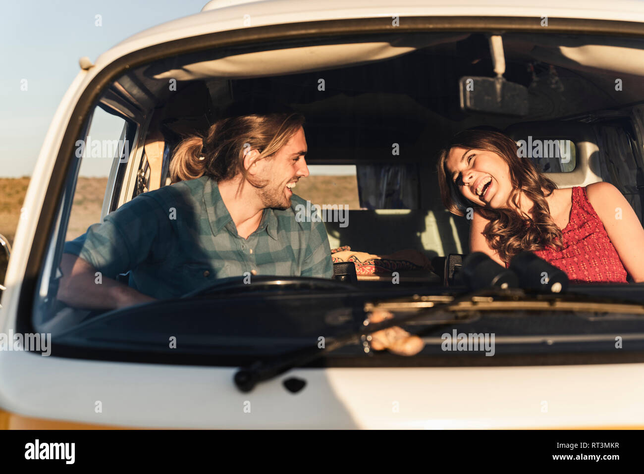 Happy couple sitting in their camper, laughing Stock Photo - Alamy