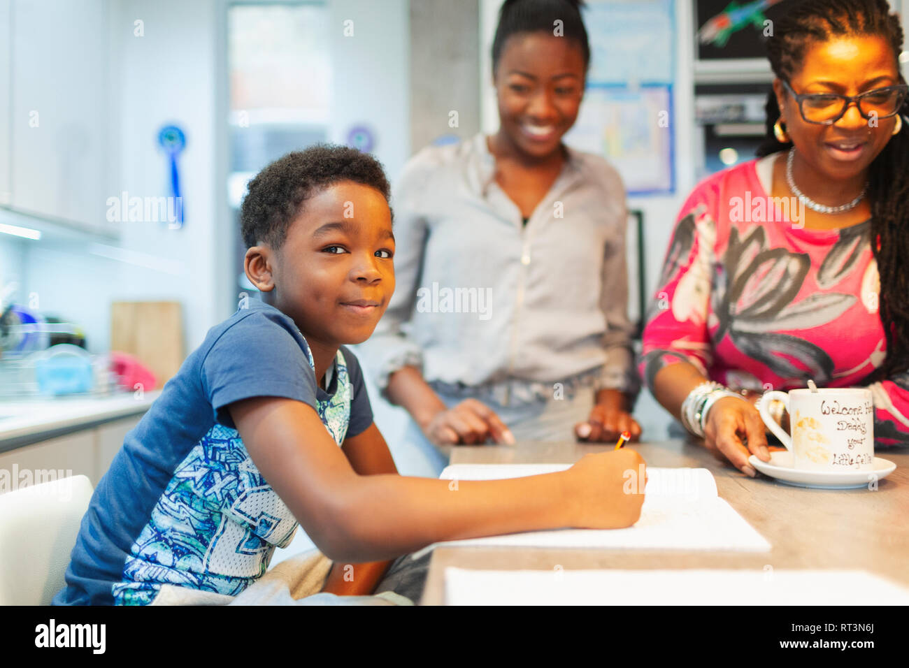 Portrait smiling boy doing homework in kitchen Stock Photo - Alamy
