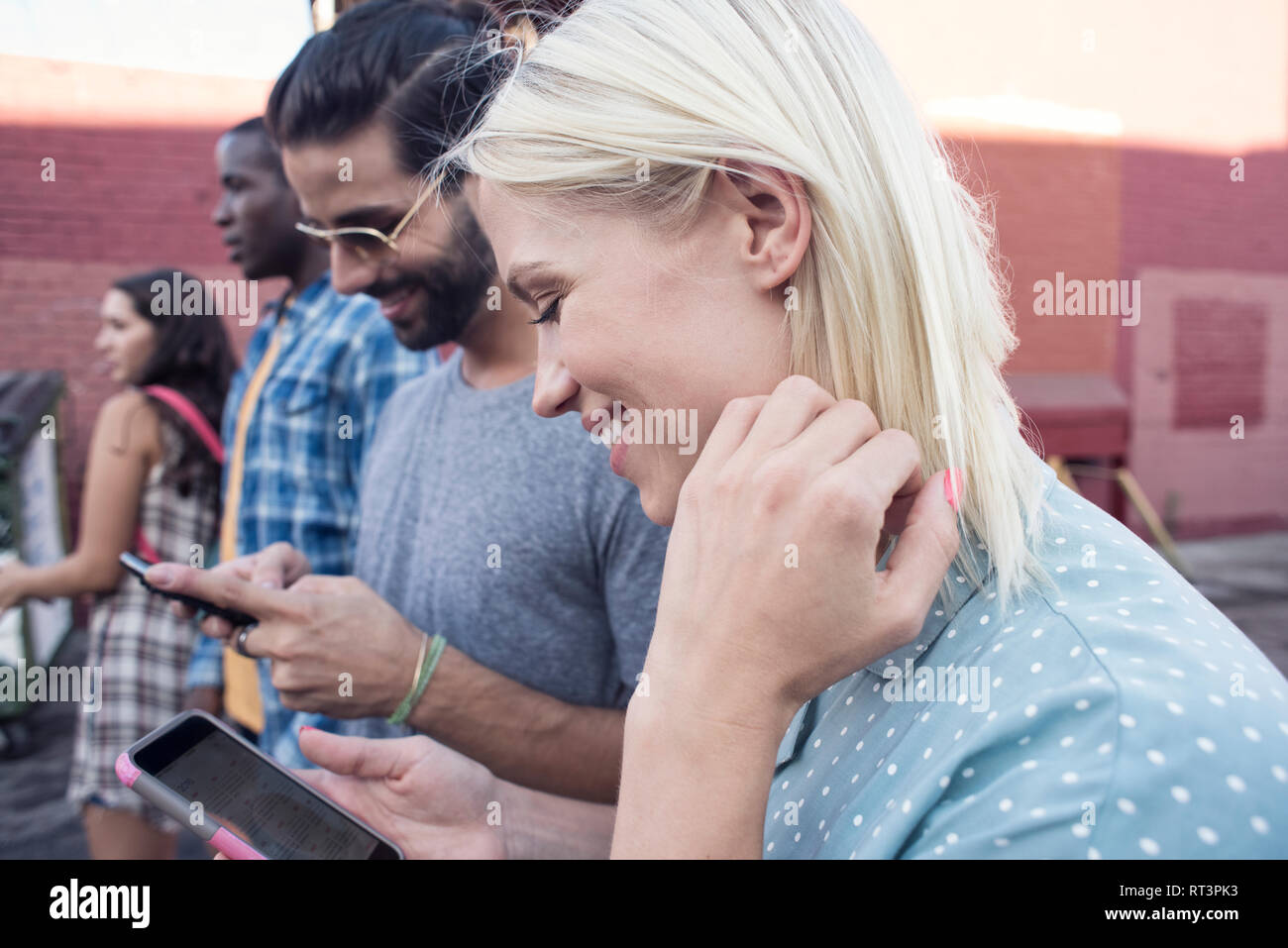 Young people using cell phones outdoors Stock Photo - Alamy