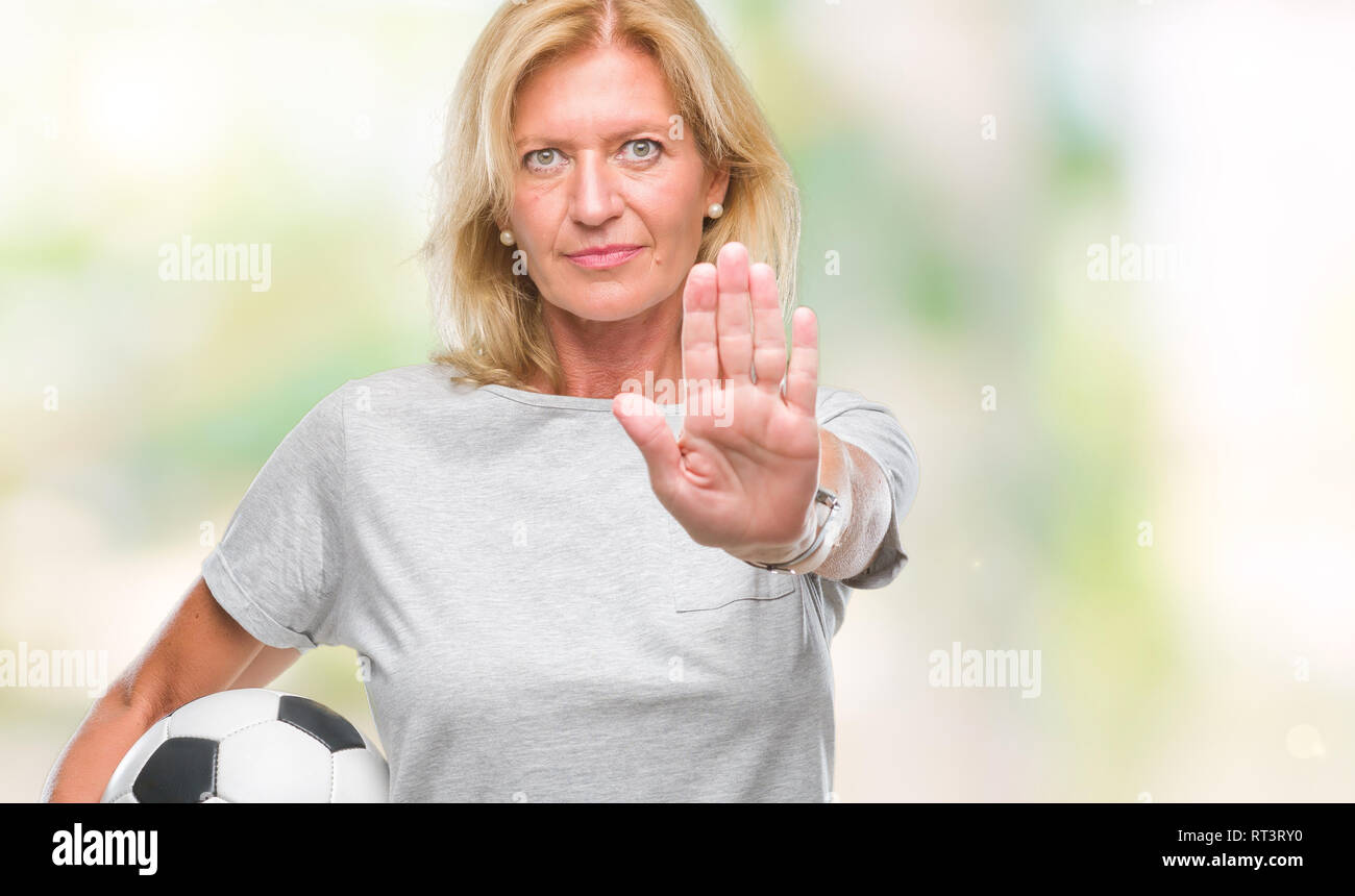 Middle age blonde woman holding soccer football ball over isolated ...
