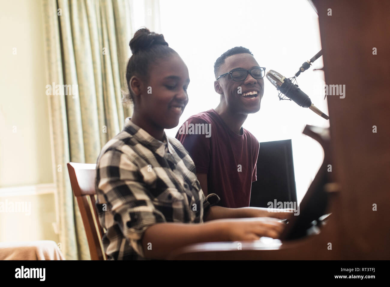 Teenage brother and sister playing piano and singing Stock Photo - Alamy