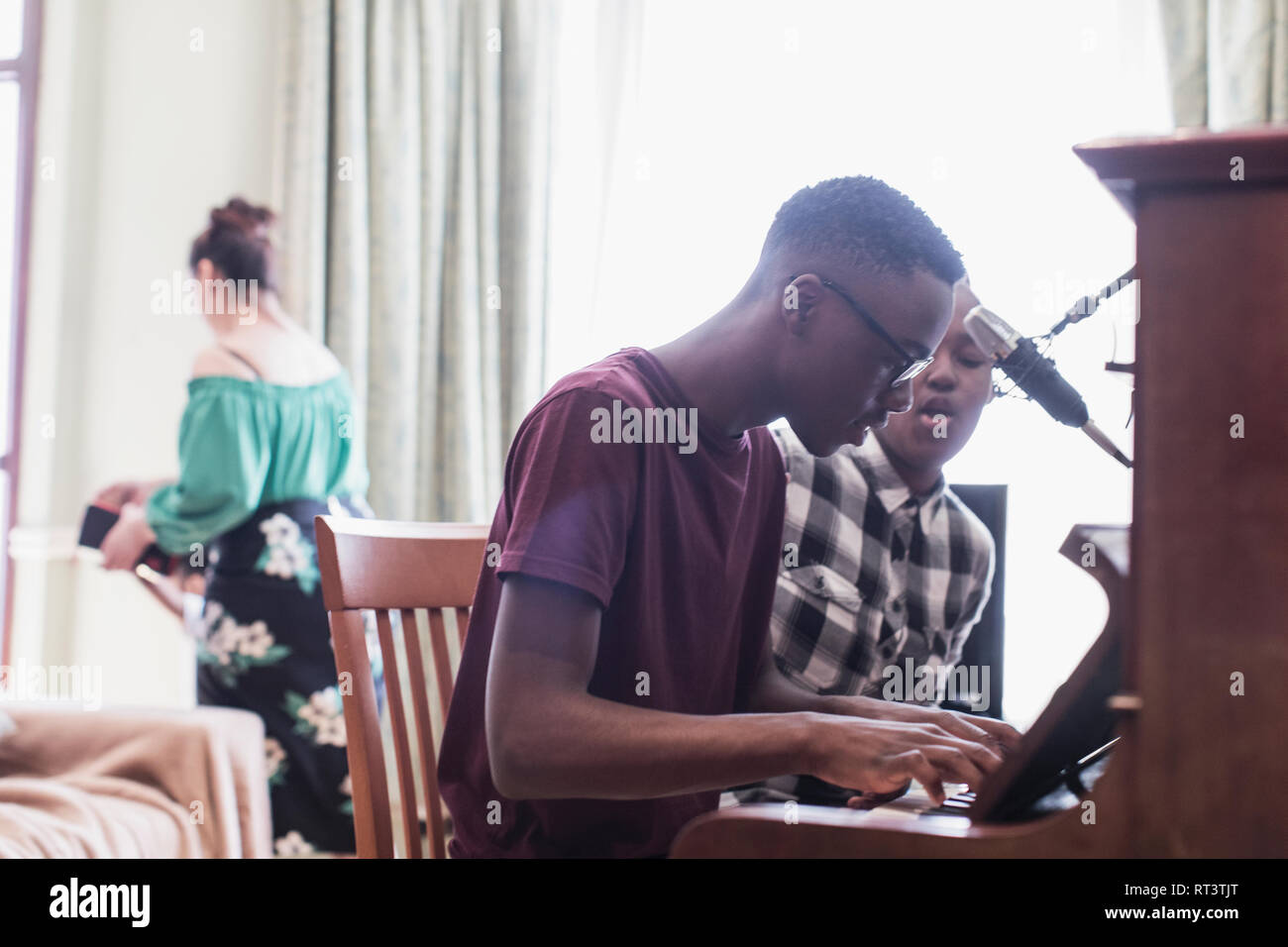 Teenage brother and sister playing piano and singing Stock Photo - Alamy