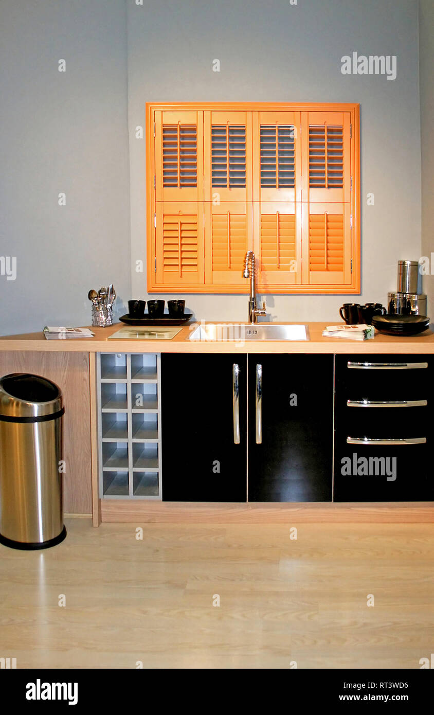 Modern small black kitchen with brown window Stock Photo - Alamy
