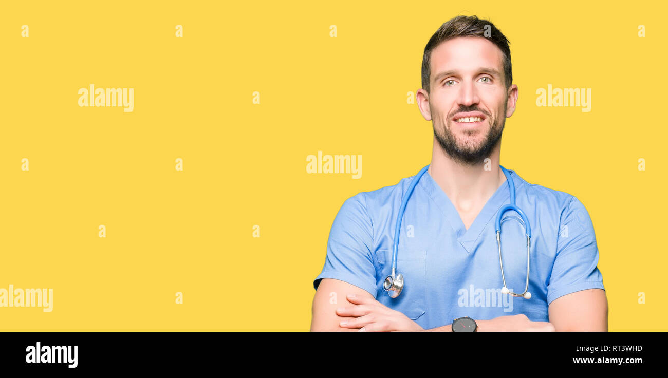 Handsome doctor man wearing medical uniform over isolated background ...