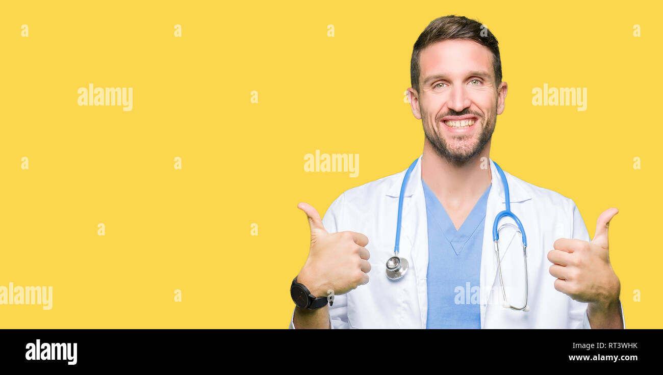 Handsome doctor man wearing medical uniform over isolated background ...