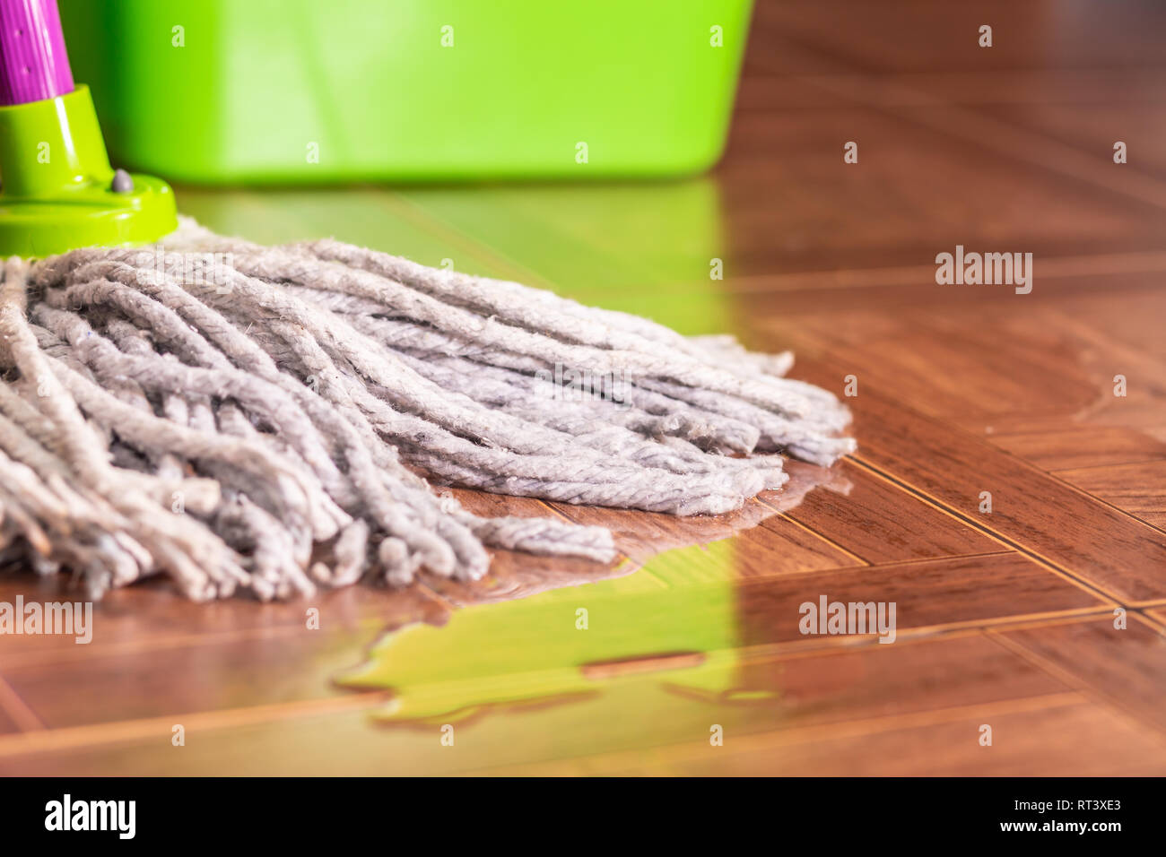 Rope mop on the tile floor and a puddle of water Stock Photo - Alamy