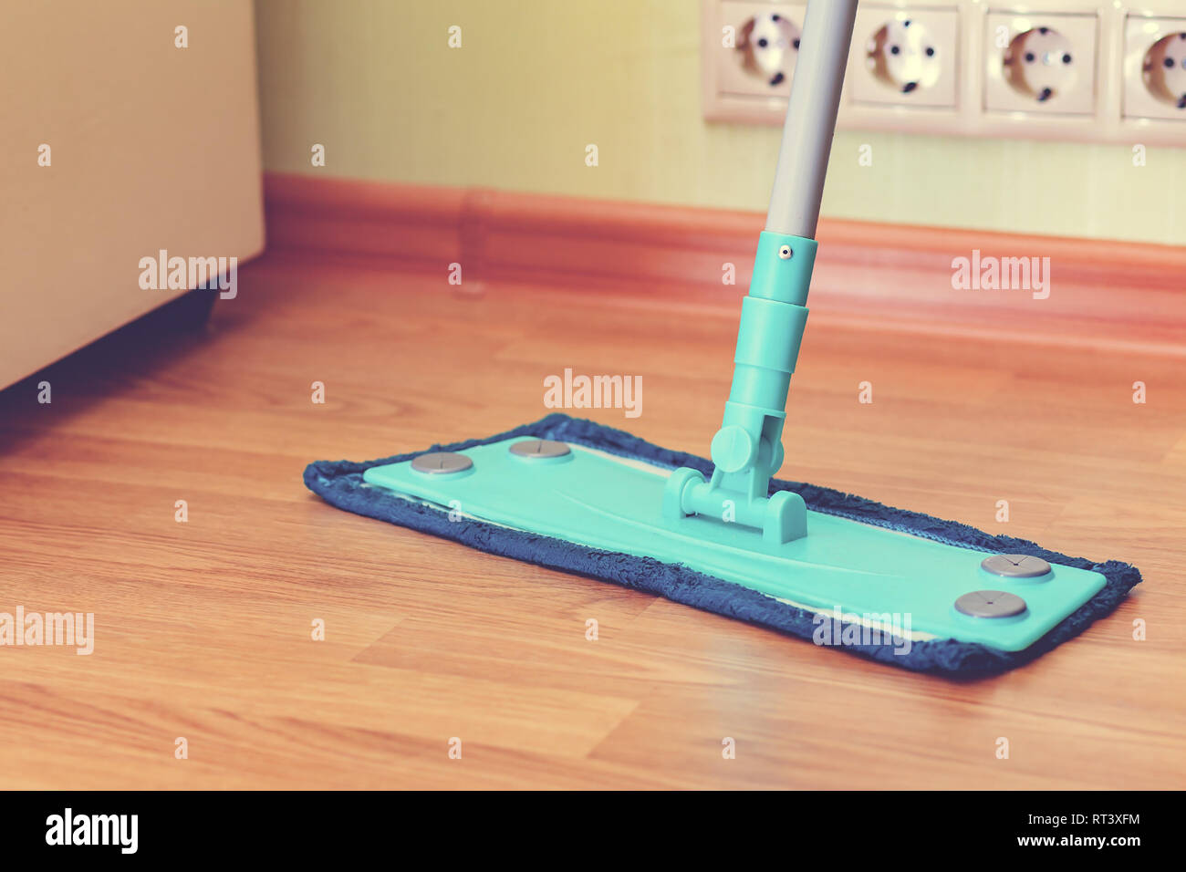 Blue mop on the floor of brown laminate Stock Photo - Alamy