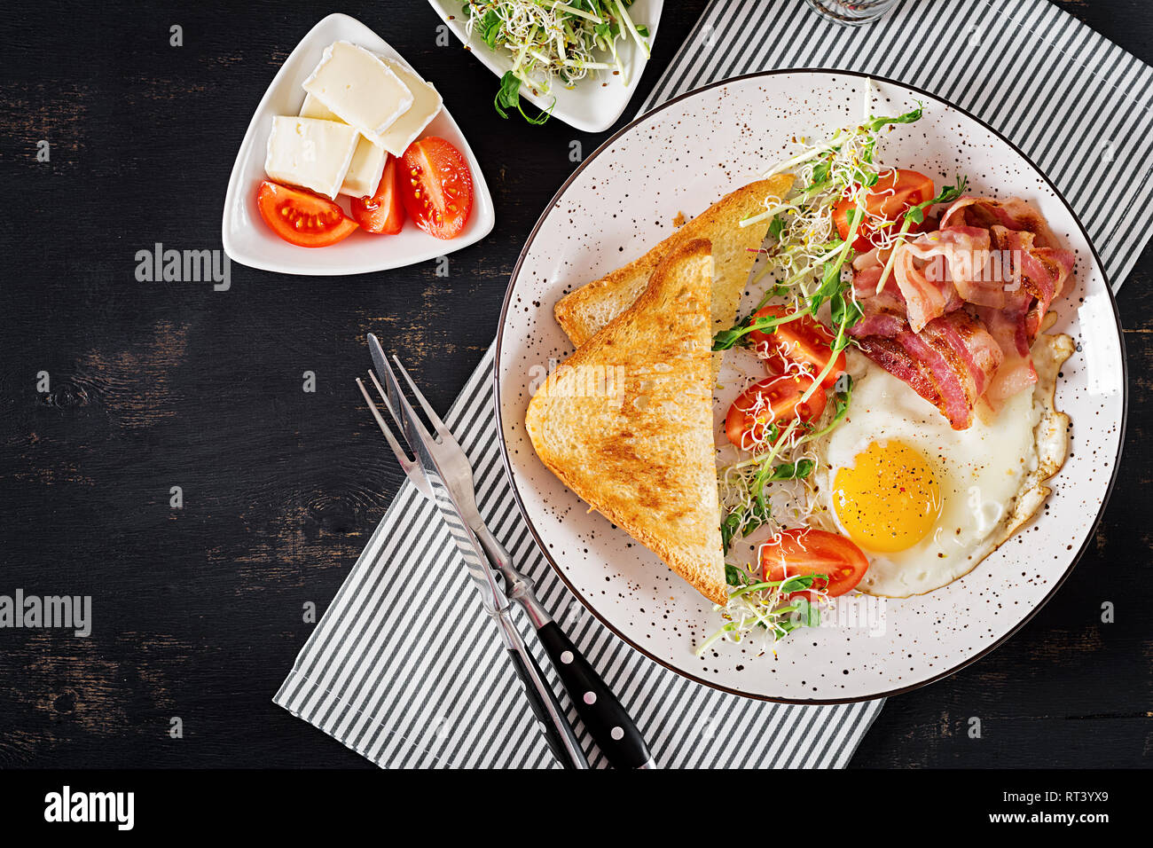English breakfast - toast, egg, bacon and tomatoes and microgreens ...