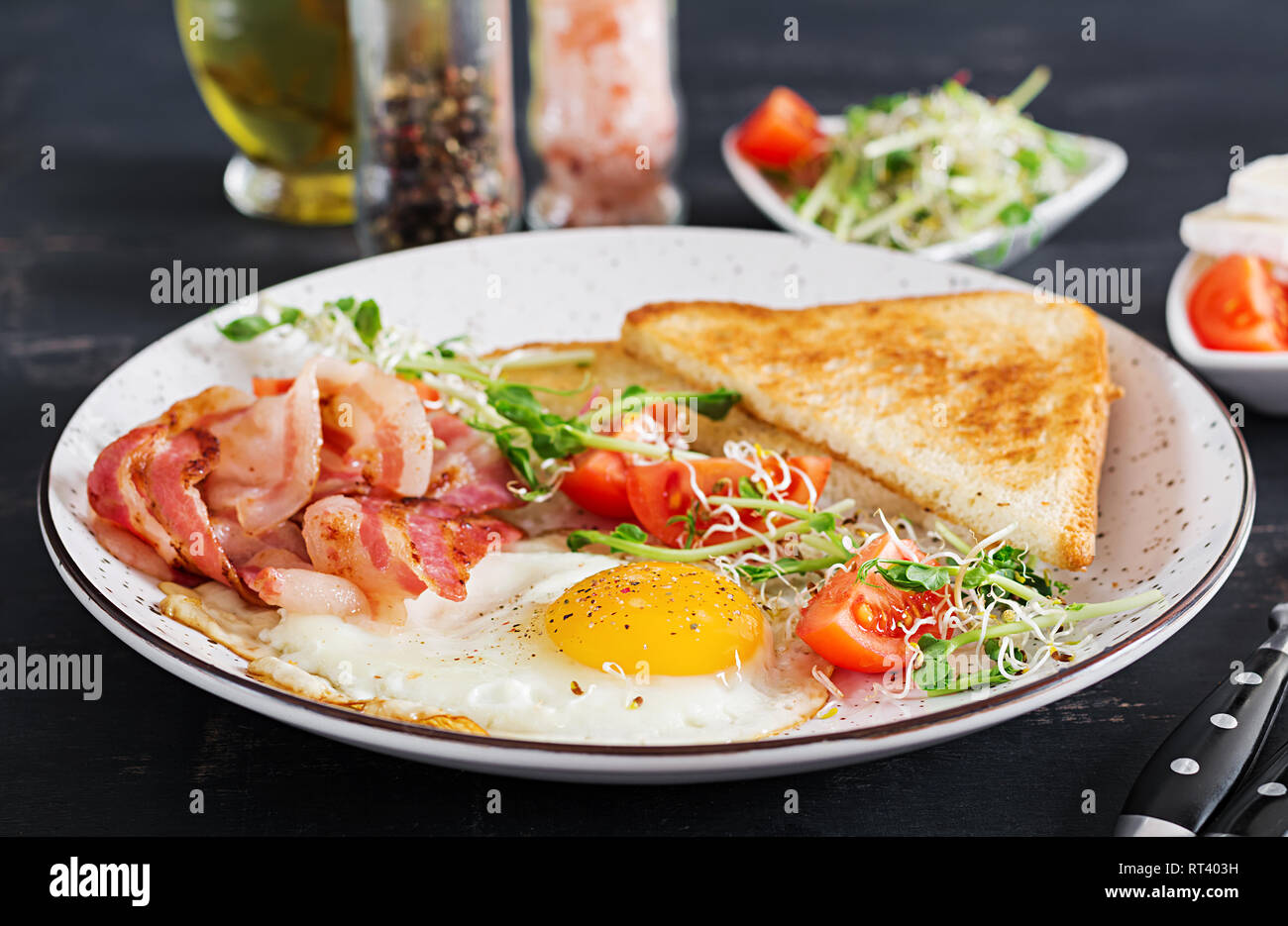 English breakfast - toast, egg, bacon and tomatoes and microgreens ...