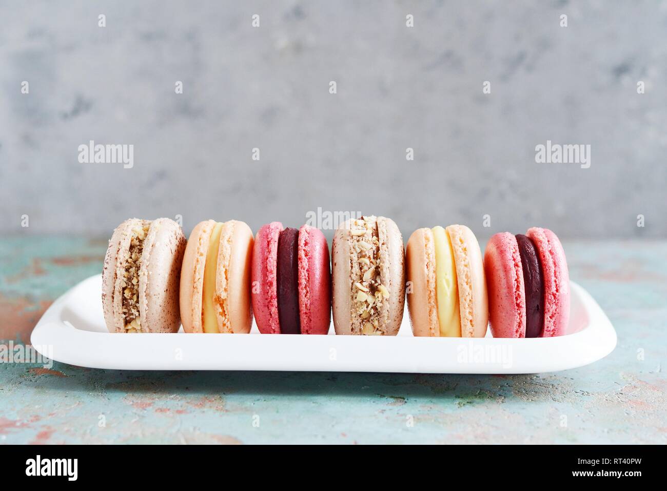French assorted macarons cakes on a rectangular dish on a gray ...