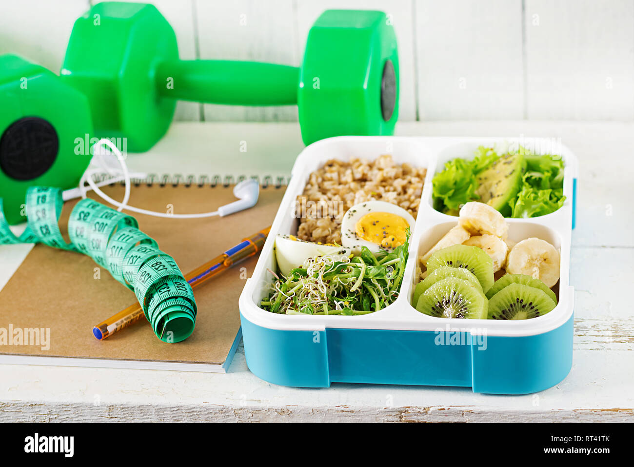 Lunch box with boiled eggs, oatmeal, avocado, micro greens and fruits ...