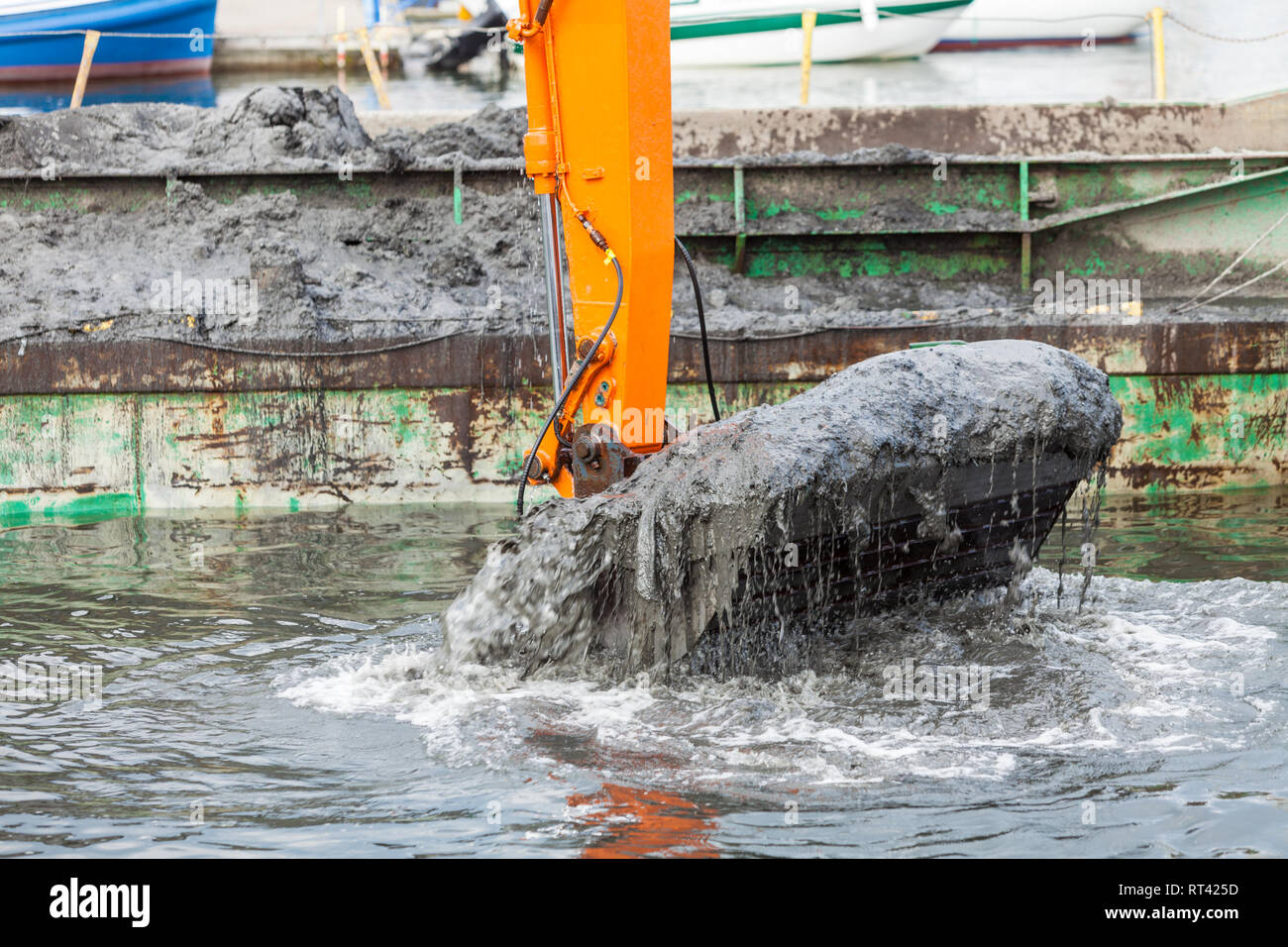 Excavator shovel digging in sand from water. Building construction ...