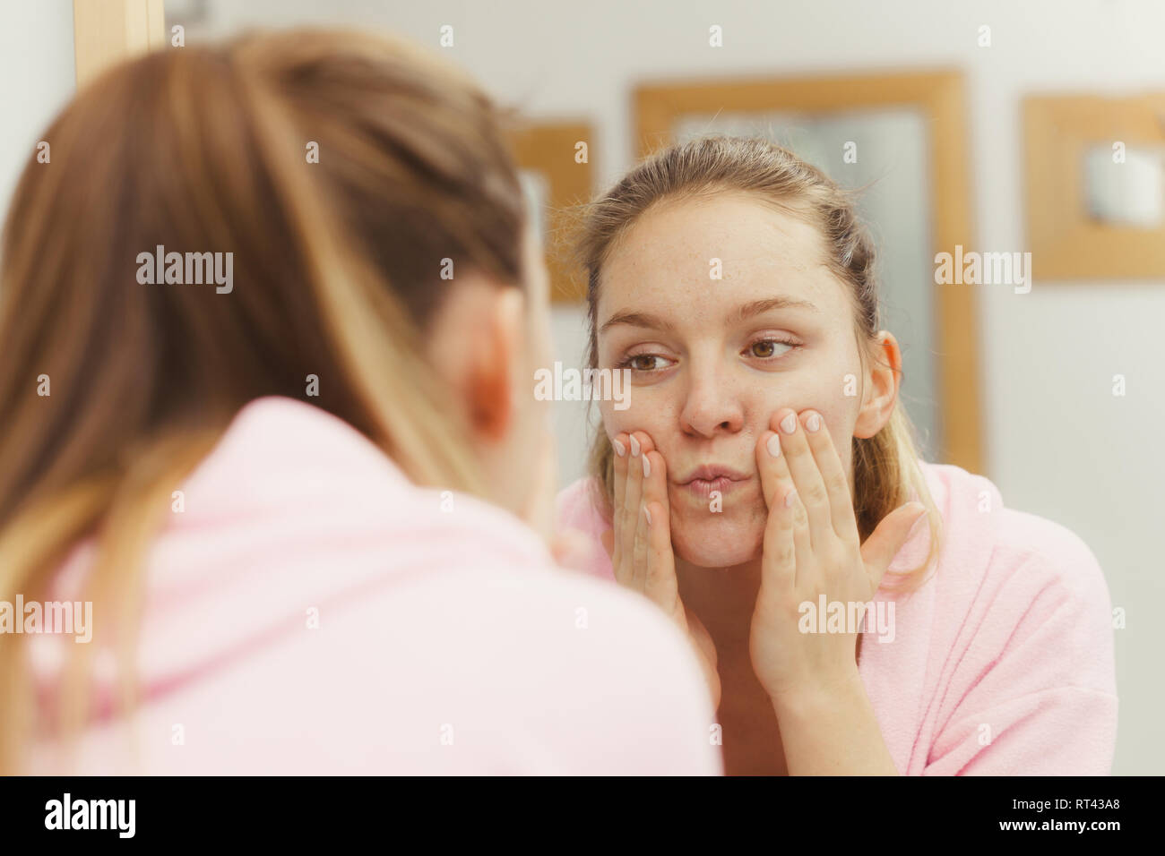 Woman cleaning peeling her face in bathroom, making facial massage with ...