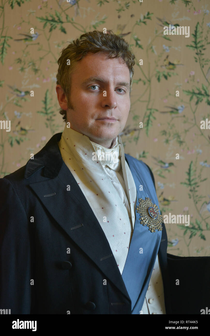 A handsome man dressed as a Victorian office wearing expensive clothes ...