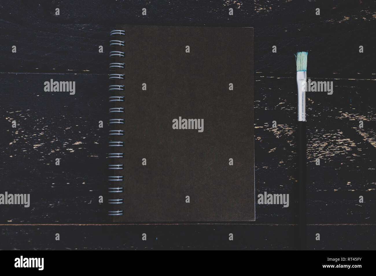 black notepad on dark desk with brushes, concept of creativity and ...