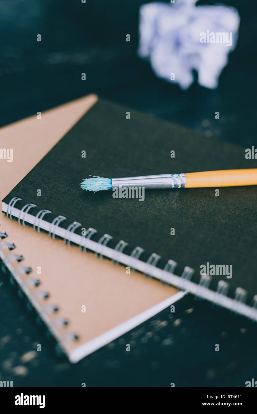 desk with notepads and watercolour brushes, concept of creativity and ...