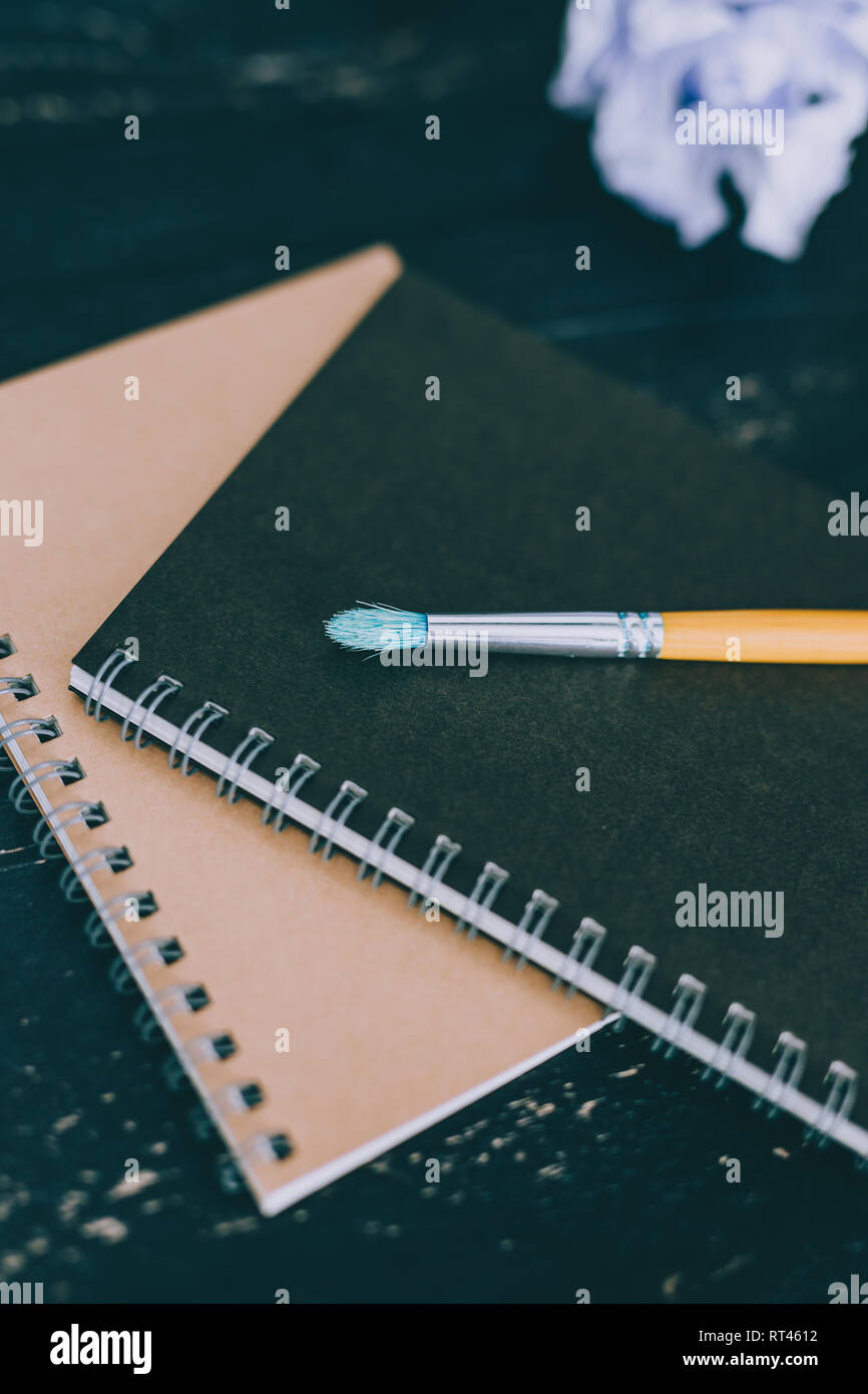 desk with notepads and watercolour brushes, concept of creativity and ...