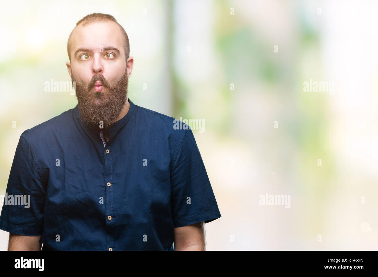 Young caucasian hipster man over isolated background making fish face ...