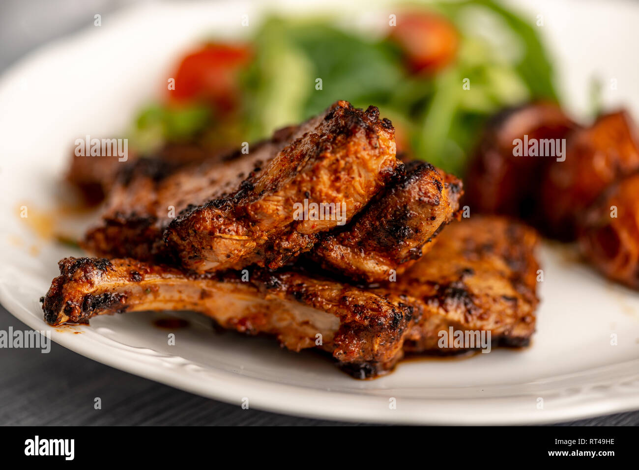 Lamb chops on a plate with vegetables and some potatoes Stock Photo - Alamy