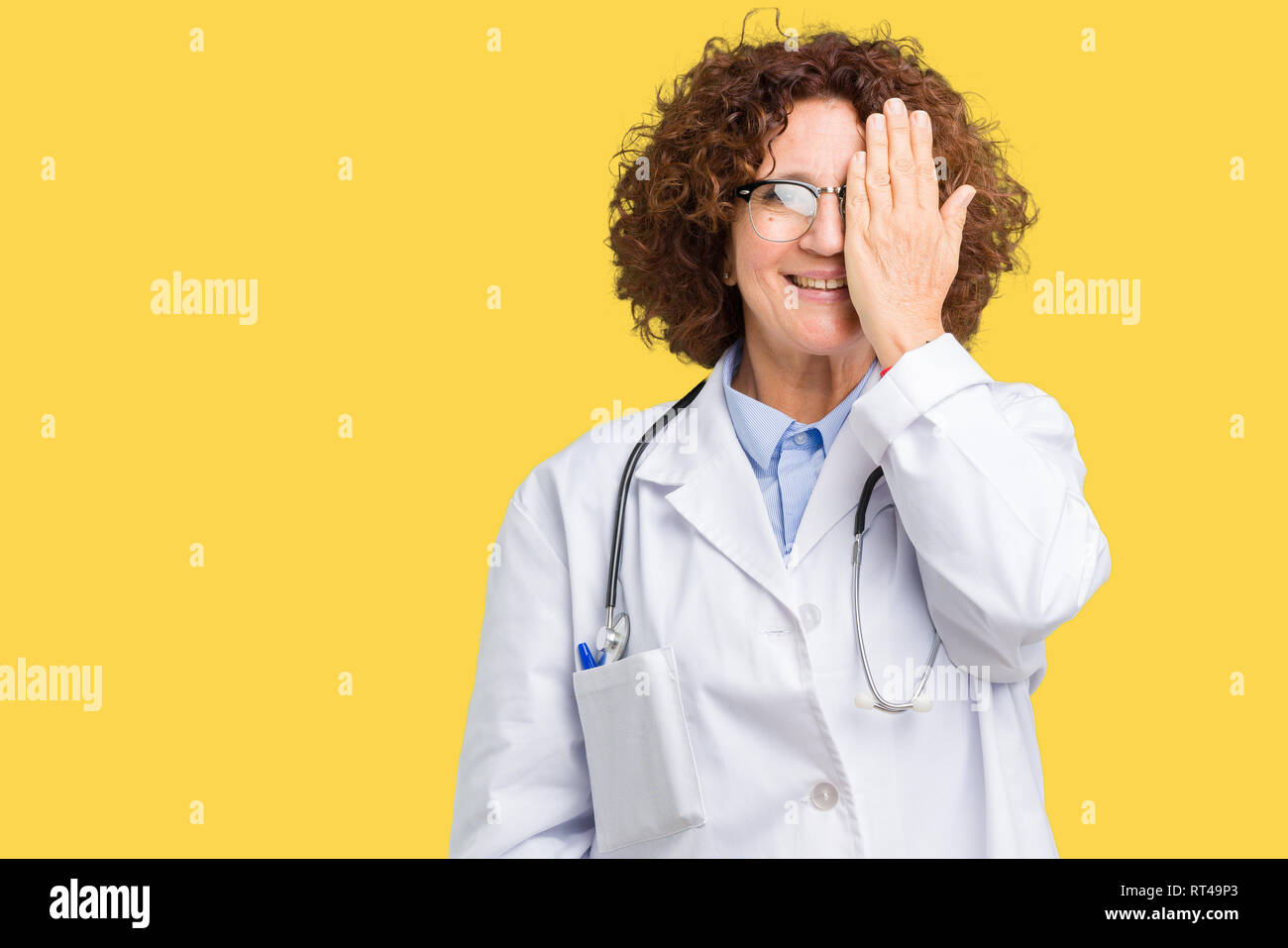 Middle ager senior doctor woman over isolated background covering one ...