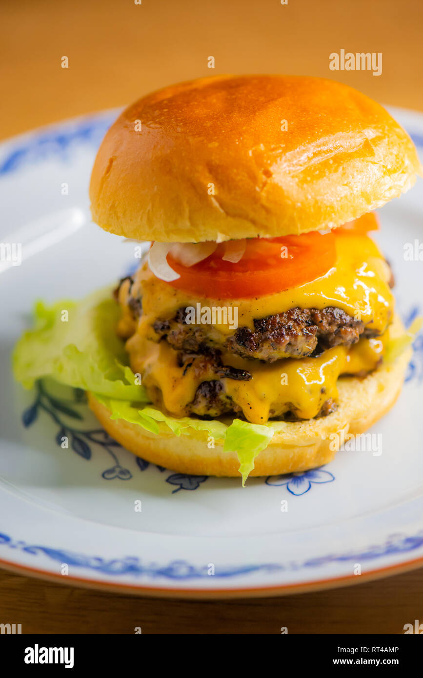 Smashed hamburger on a plate with melted cheese Stock Photo - Alamy