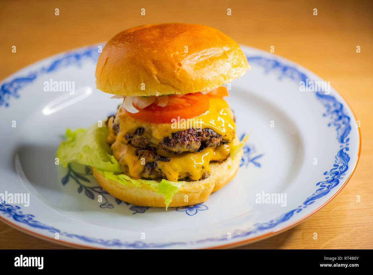 Smashed hamburger on a plate with melted cheese Stock Photo - Alamy