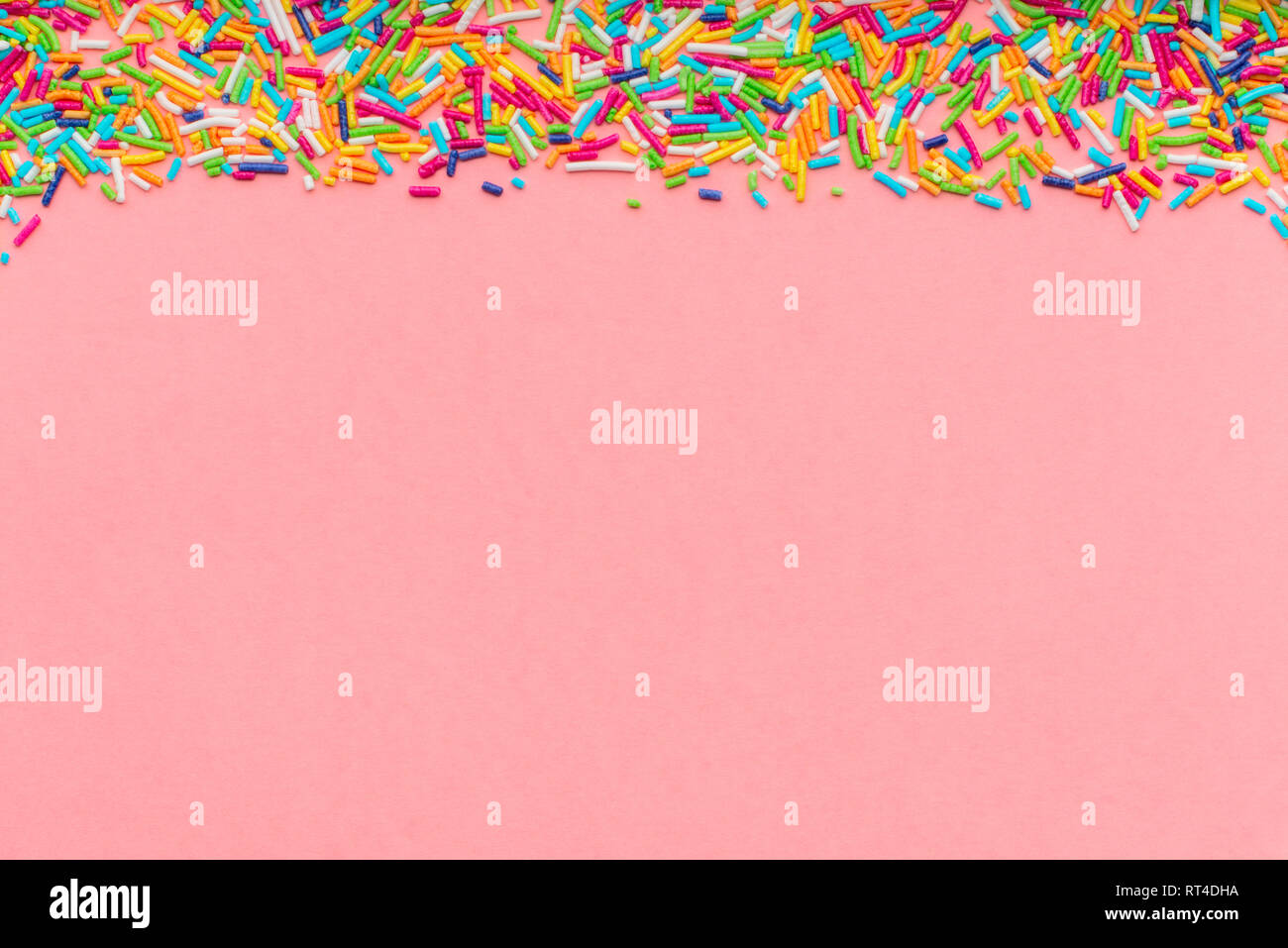 greeting card of colorful sprinkles over pink background, festive ...