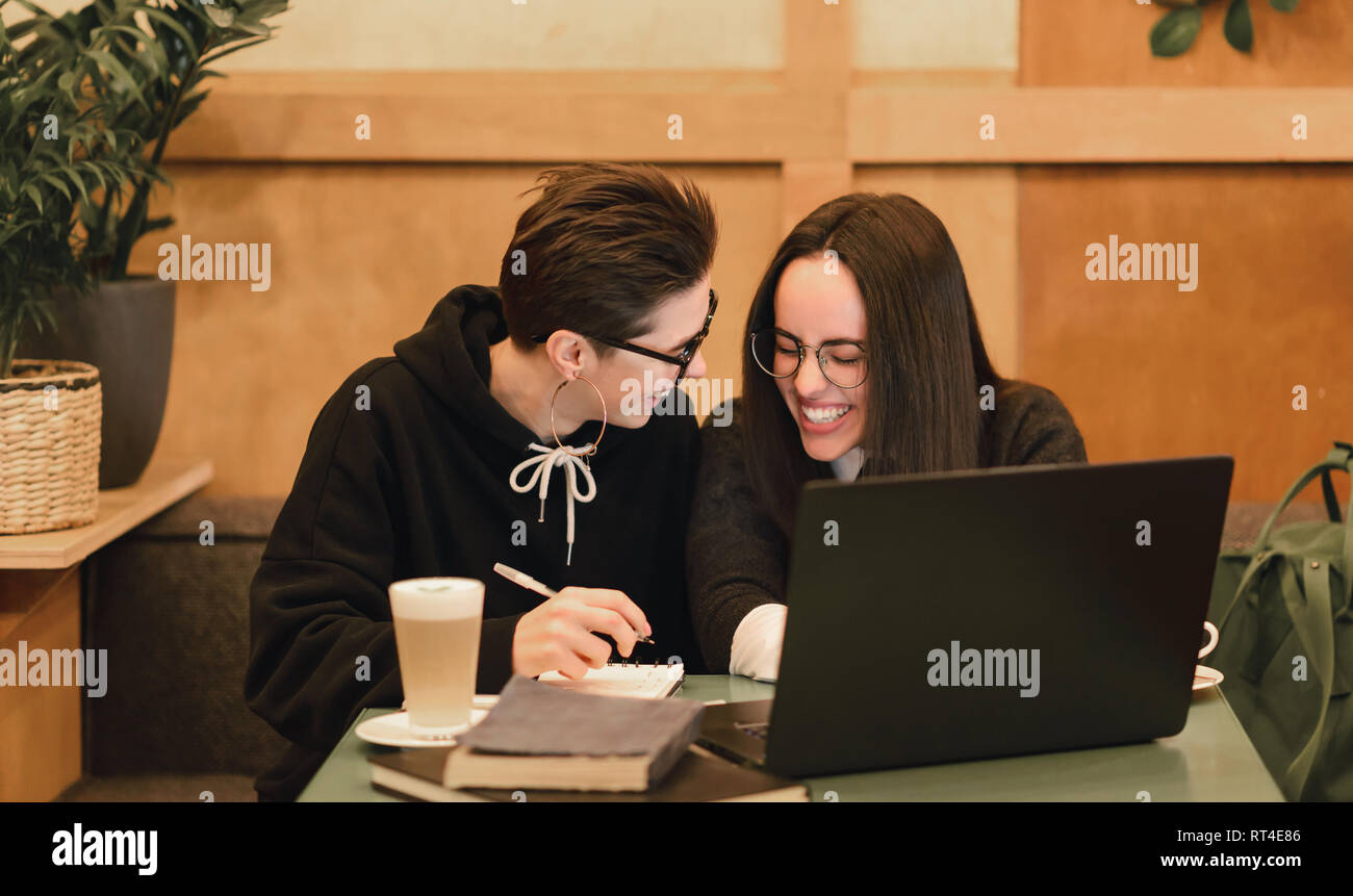 Young happy students having fun while learning together in cafe ...