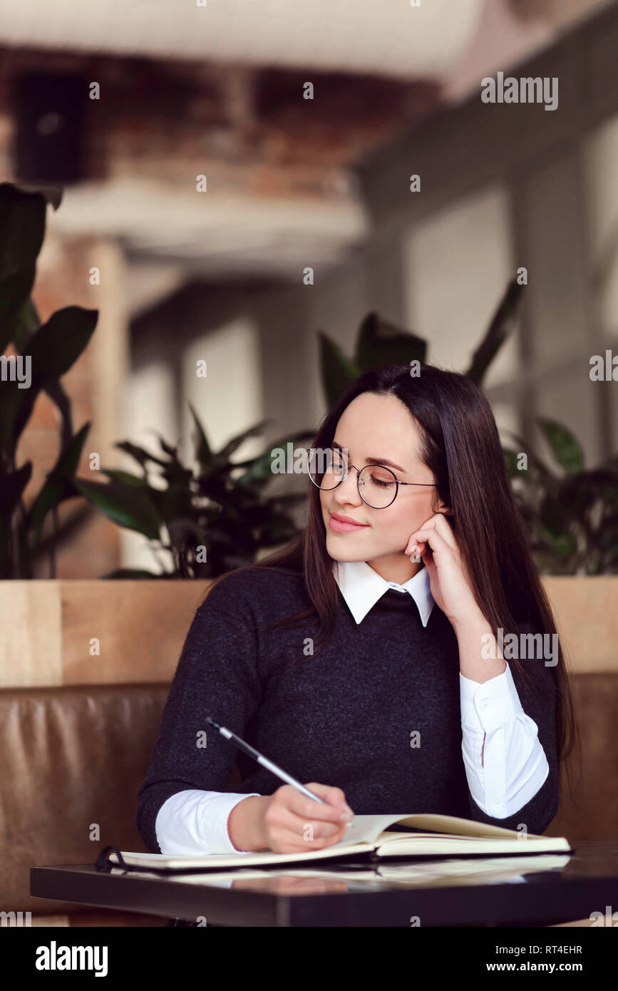 Univercity girl wearing uniform close her eyes while writting something ...