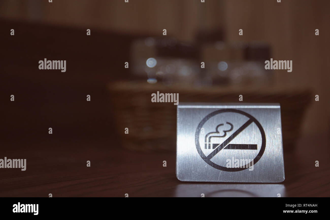 Warning sign. no smoking on the table in the room. Iron plate on the ...
