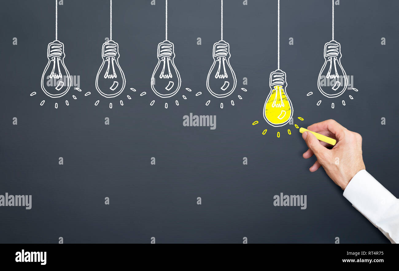 teacher drawing yellow brigh bulb on blackboard Stock Photo - Alamy